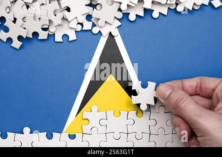 Saint Lucia flag depicted in bright paint colors on old relief ...