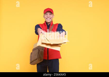 Happy postman with bag giving envelopes on light blue background Stock ...