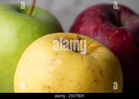 Three apples of different varieties and colors: red, yellow, green ...