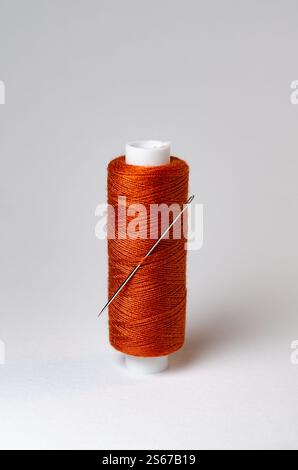 One single red thread spool with needle on white background Stock Photo ...