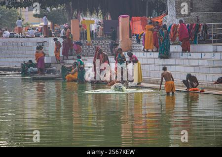 Life at Dhanushsagar Pond. Pilgrims bathing, washing clothes, and ...