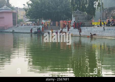 Life at Dhanushsagar Pond. Pilgrims bathing, washing clothes, and ...