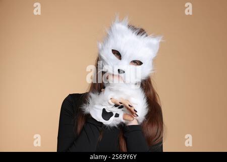 Quadrobics. Girl wearing cat mask and gloves on beige background Stock ...