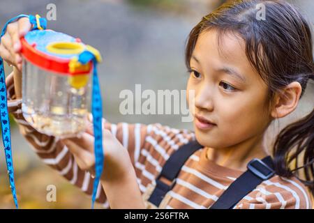 Happy girl taking a look at the fish she caught Stock Photo - Alamy