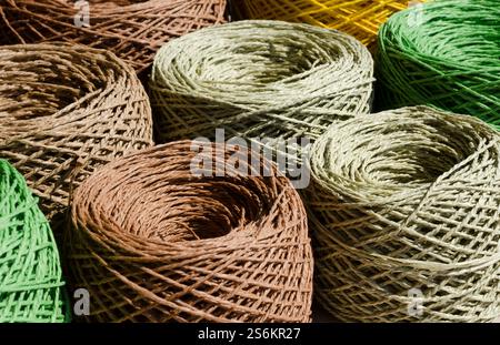Raffia rolls close-up. Skeins of multi-colored raffia on a white ...