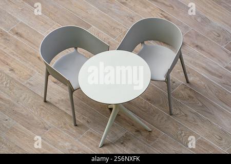 Comfortable chairs placed on wooden terrace near wall of residential ...