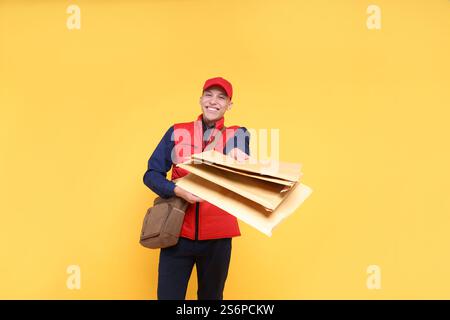 Happy postman with bag giving envelopes on yellow background Stock ...