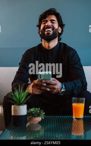 Pakistani young manwith traditional outfit using smart phone on the ...