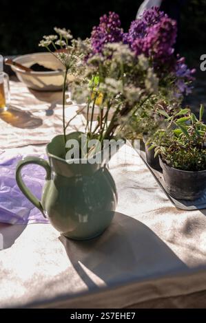 Vase with lilac flowers and cloth on table in room Stock Photo - Alamy