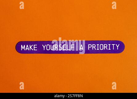 Make yourself a priority message written on wooden block with red ...