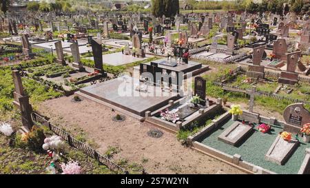A quiet cemetery scene with rows of weathered tombstones under green ...