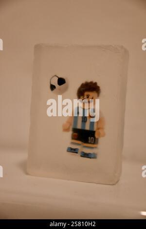 a lego style mini figure of lionel messi encased inside a clear bar of ...