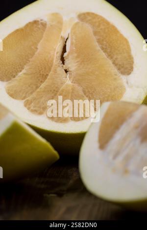 one pomelo with lots of pulp cut into pieces, huge juicy citrus closeup ...