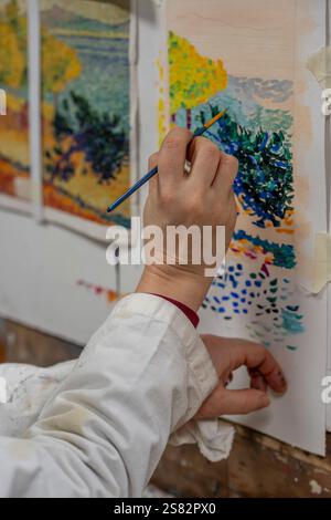 Artist's hand holding paintbrush painting calligraphy on canvas Stock ...