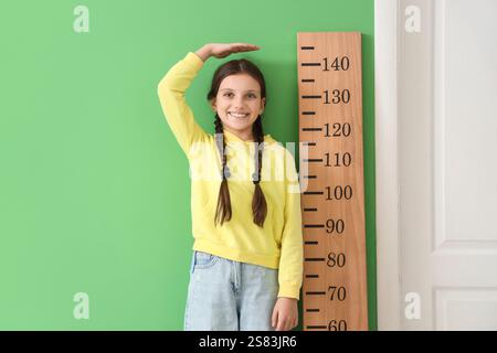 Cute girl measuring height near stadiometer at home Stock Photo - Alamy