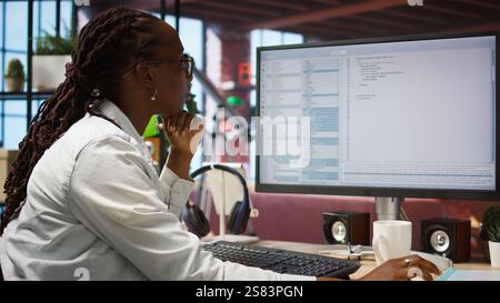 Woman feeling worried while looking at UI on PC screen, having trouble executing programming ...