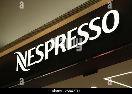 Close-up of Nespresso logo sign mounted on stone building facade under ...