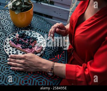 Person in a red outfit sits on a sofa using a smartphone in a modern ...
