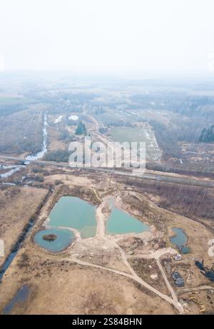 Aerial perspective of a rural area featuring a small pond, open fields ...