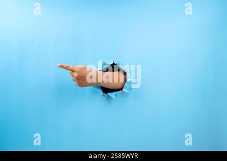Human hand showing from ripped paper. Hand gestures of pointing. Mockup ...