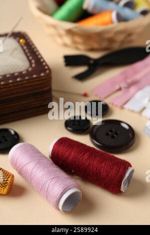 Sewing threads with buttons on beige background Stock Photo - Alamy