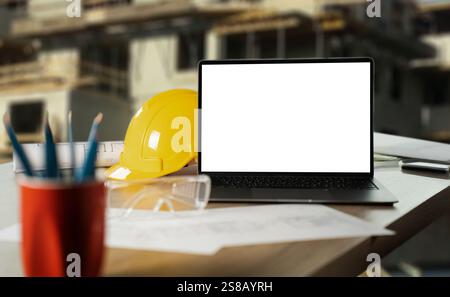 Workplace concept with open laptop and yellow wired blank notebook ...