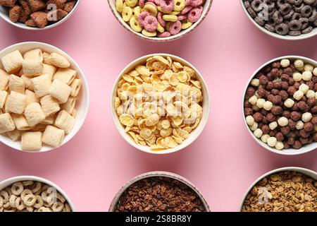 Bowls with different cornflakes on pink background Stock Photo - Alamy
