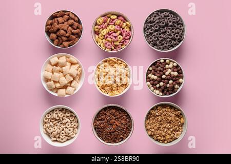 Bowls with different cornflakes on pink background Stock Photo - Alamy