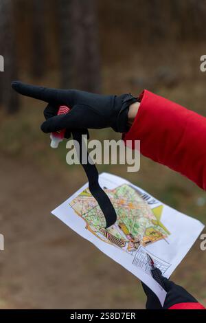 Woman holding a map and the compass during orienteering competitions ...