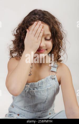 Portrait of joyful girl covering her eye by a cream can. She is looking ...