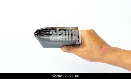 A tanned hand holding an ugly and broken wallet on a white background ...
