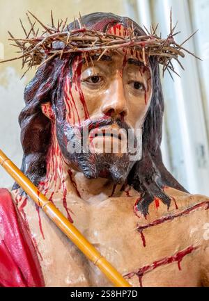 maltreated and bleeding face of Jesus with crown of thorns and wooden ...