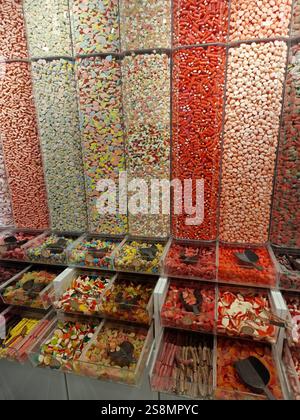 Colorful array of assorted gummy candies presented in containers ...