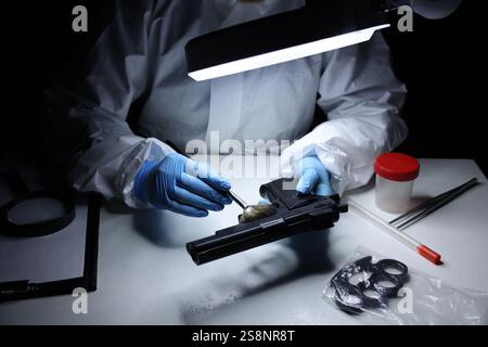 Forensic expert taking fingerprints with brush from handle of door ...