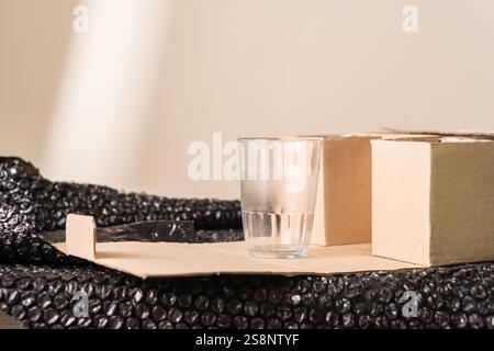 Clear glass coffee cup surrounded by used coffee pods on wooden table ...