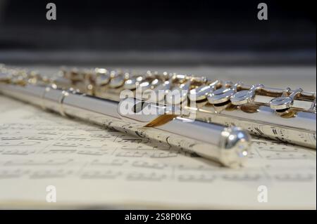 Silver flute lying on a sheet of music Stock Photo - Alamy
