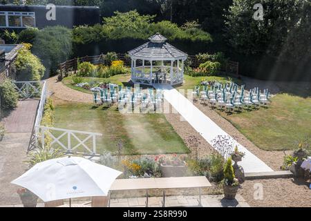 Outdoor wedding ceremony setup with white chairs and floral arch Stock ...