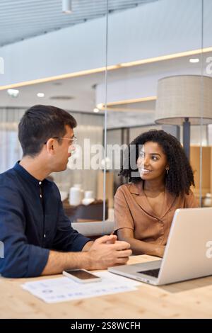 Two busy happy diverse professional coworkers discussing project at ...