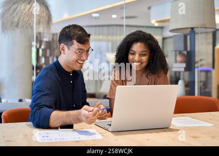 Diverse work team working together at laptop during meeting Stock Photo ...