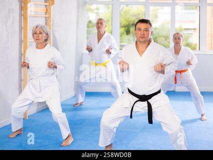 Elderly women and men in kimonos stand in a fighting stance during ...