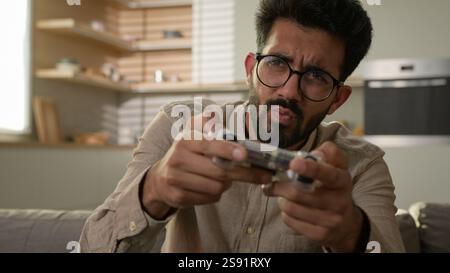 Addicted male gamer Arabian Indian man guy on couch play video game ...