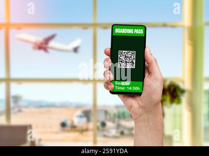 Man showing QR electronic boarding pass to flight on phone with white ...