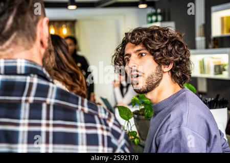 Young curly man expressing surprise and looking aside isolated over ...