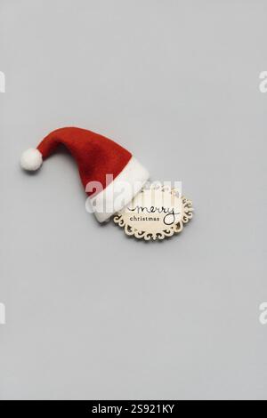 Creative photo of Santa hat and holly berry made of paper on a white ...
