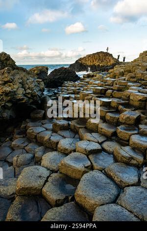 Tourists climb the basalt rocks at the GIant's Causeway, Ireland ...