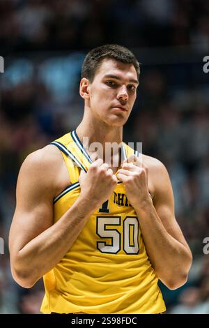 Michigan center Vladislav Goldin (50) carries the trophy after an NCAA ...