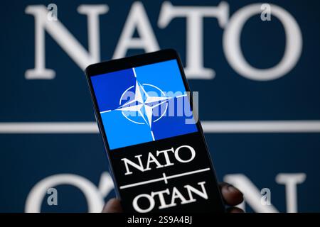 The NATO - OTAN logo is being displayed on a mobile phone with the NATO ...