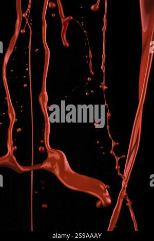Blood flowing down in streams and drops, isolated against a black ...