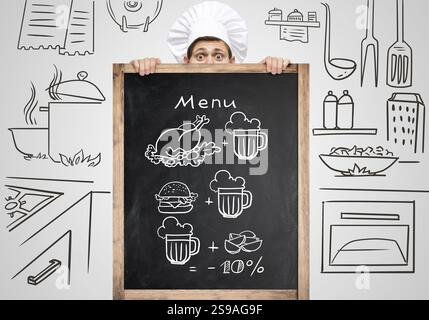 Restaurant chef hides behind a large chalkboard for a business lunch ...