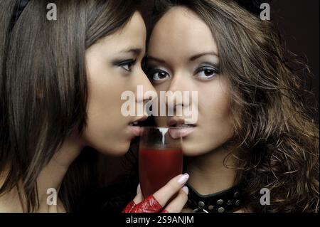 Two women in outlandish carnival costumes. Devil figure Stock Photo - Alamy